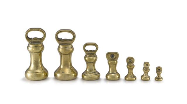 Seven brass bell-shaped balance weights, various makers | Strauss & Co