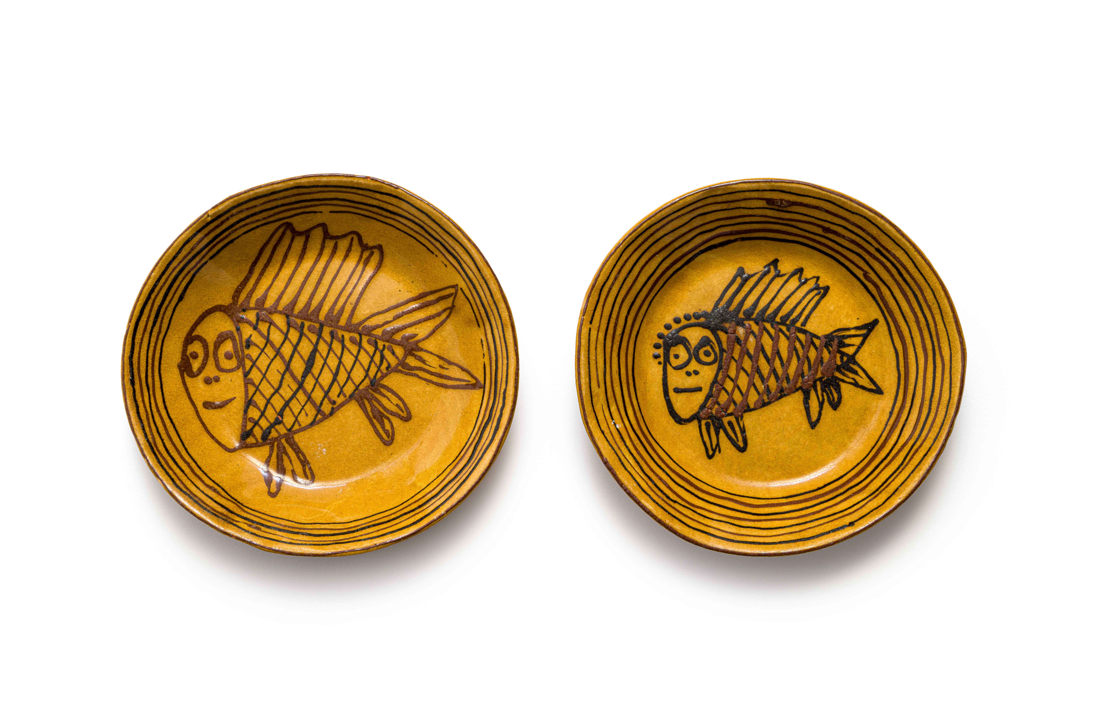 A pair of yellow dishes with brown fish motif, two by Hylton Nel ...